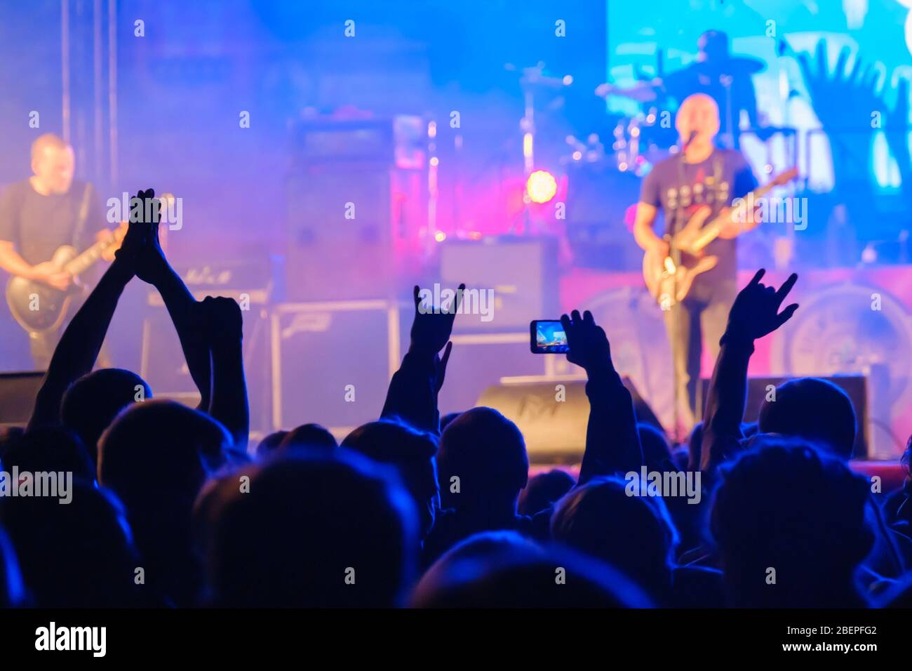 Fans listening to rock band on stage Stock Photo - Alamy