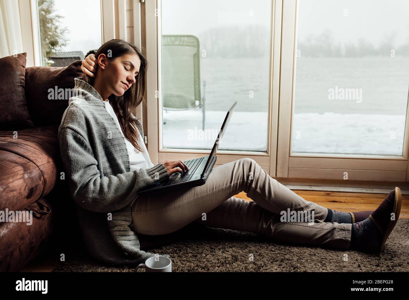 Woman working from home in room with a view on a lake/river.Working ...