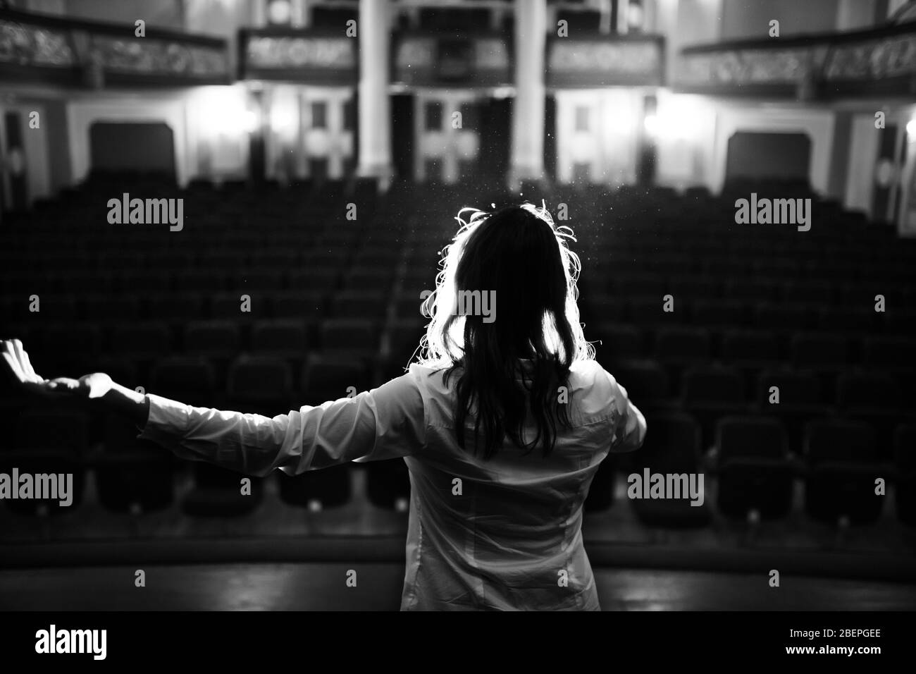 Entertainer performing on a stage in a empty theater,concert hall ...
