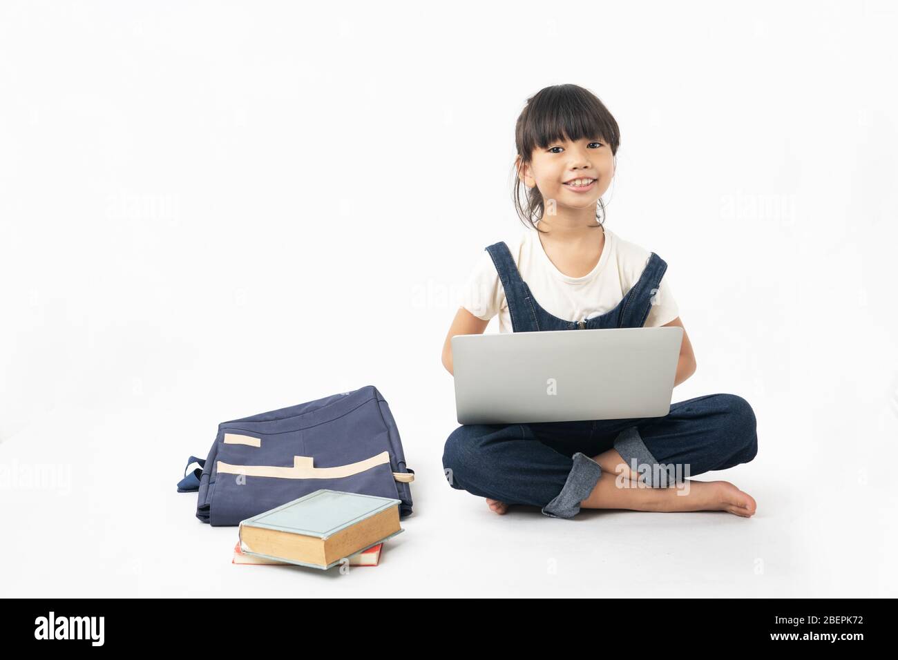 Young girl sitting and using laptop isolated on white background Stock ...