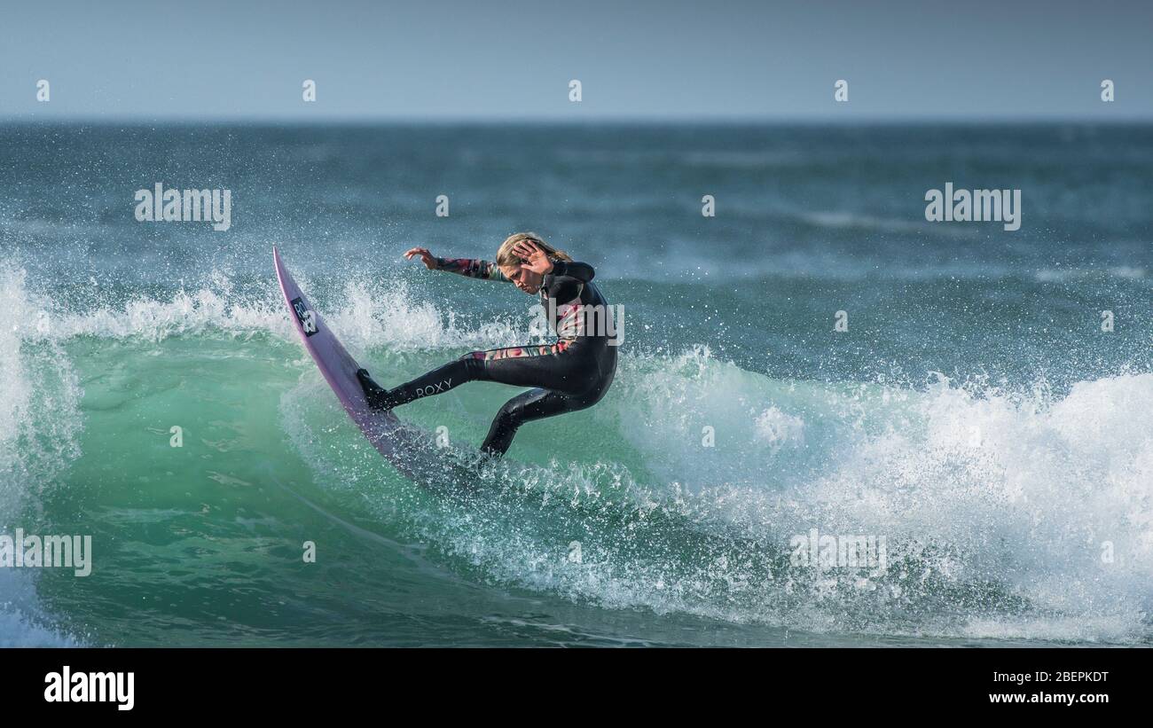 A teenage female surfer surfing at Fistral in Newquay in Cornwall Stock ...