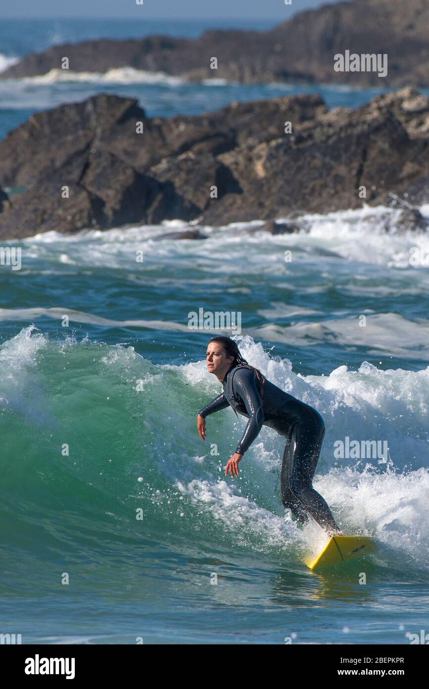 A female surfer riding a wave at Fistral in Newquay in Cornwall Stock ...
