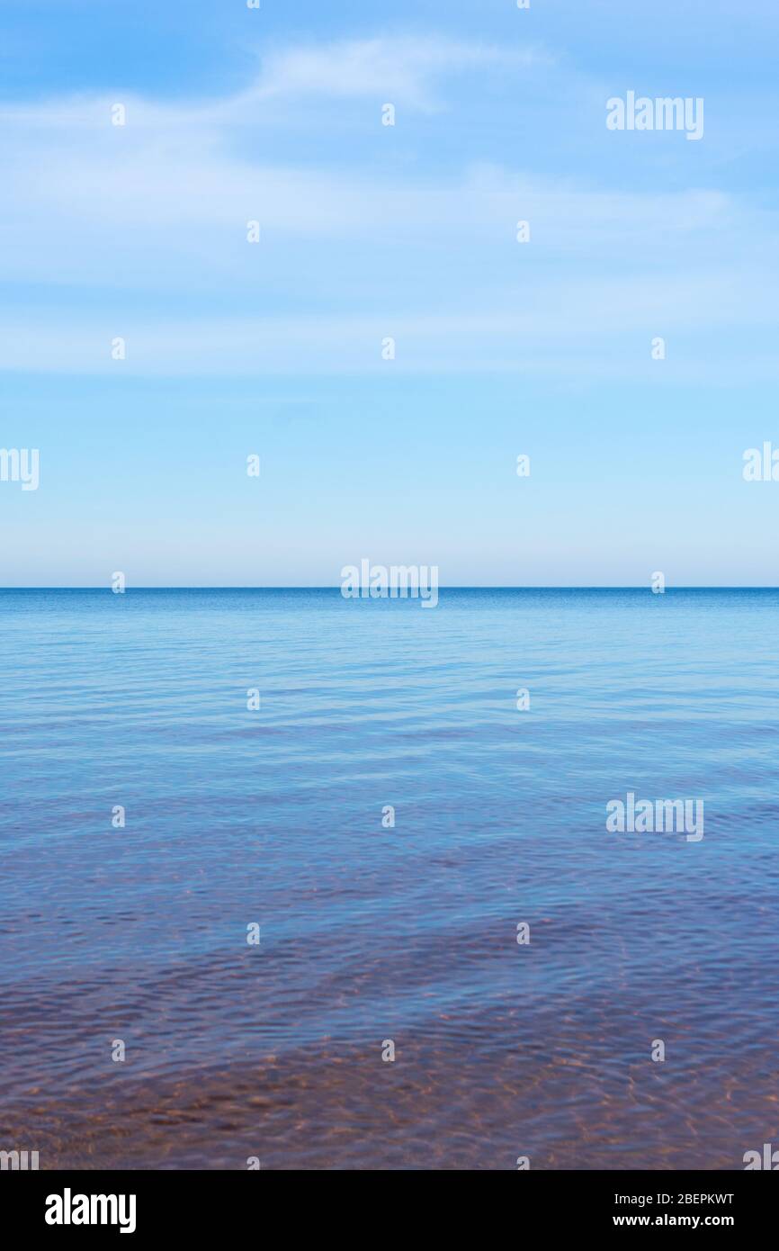selective focus, flat horizon line, blue lake with cloudy sky in the ...