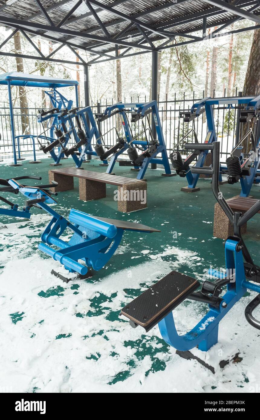 An outdoor gym covered with snow. Empty fitness zone of a public park ...