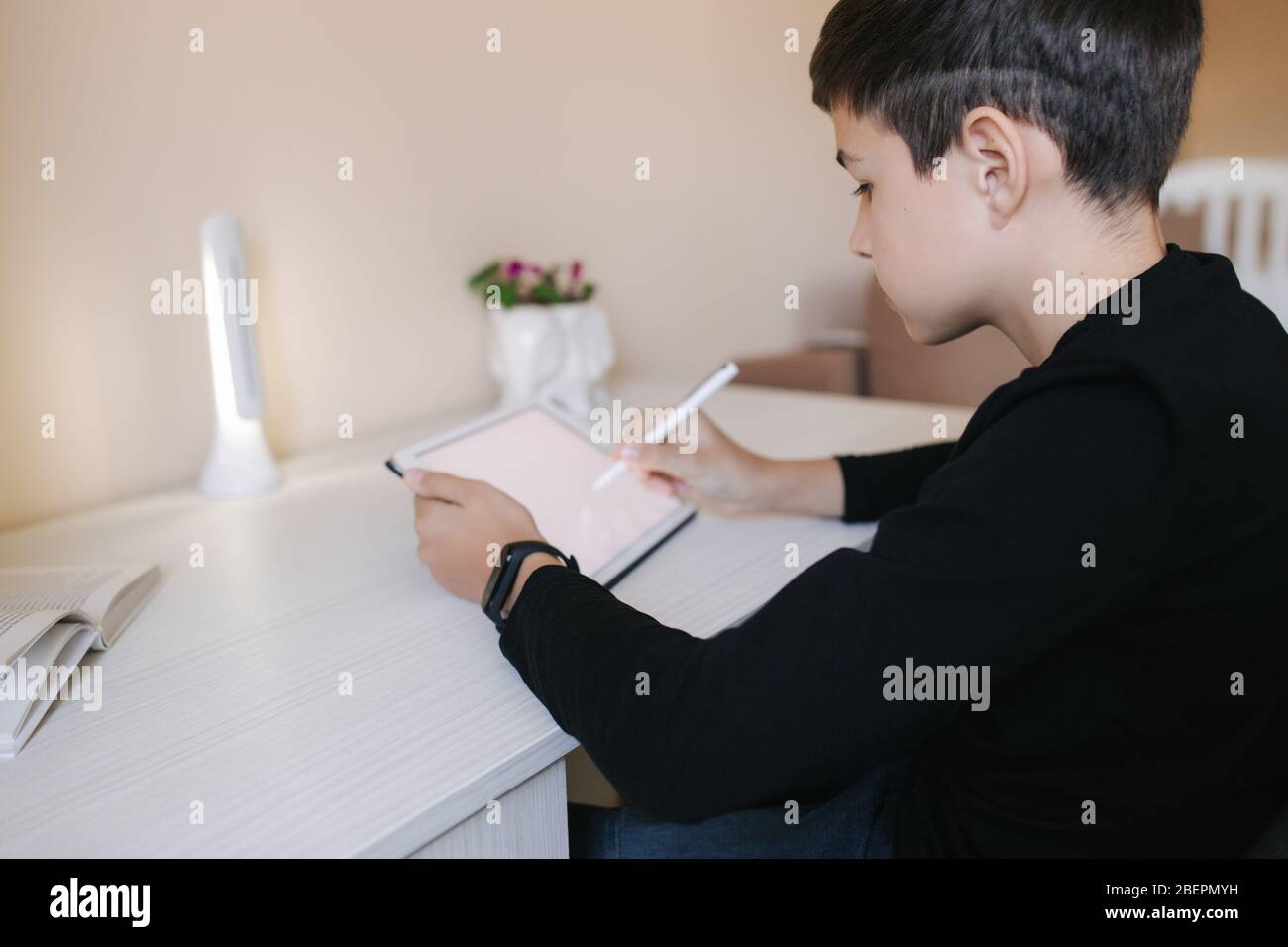 Handsome young boy drawing on tablet at home. Teenage boy use tablet ...