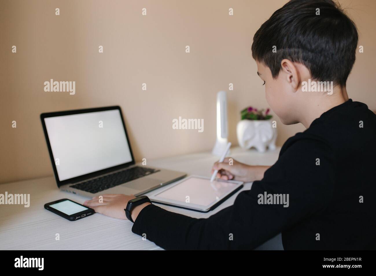 Handsome young boy drawing on tablet at home. Teenage boy use tablet ...