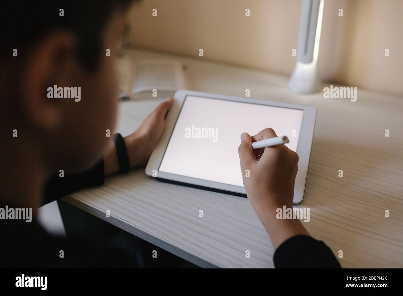 Handsome young boy drawing on tablet at home. Teenage boy use tablet ...