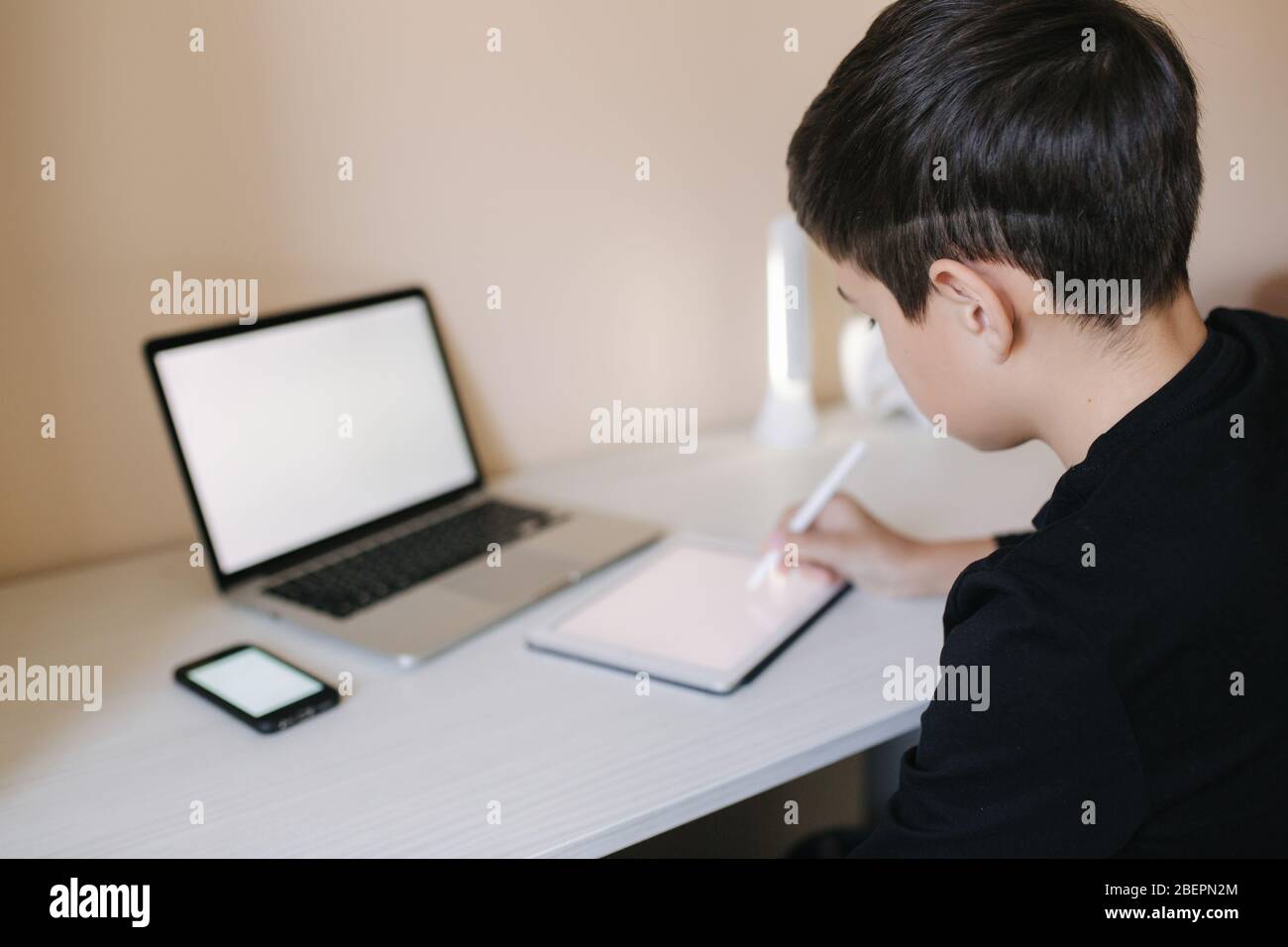 Handsome young boy drawing on tablet at home. Teenage boy use tablet ...