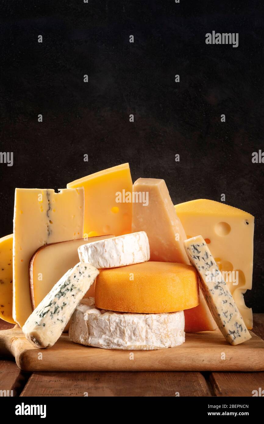 Cheese variety, many different types of cheeses, a side view on a black ...
