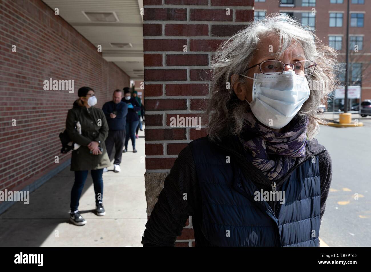People wearing protective masks in line at the grocery store, Boston ...