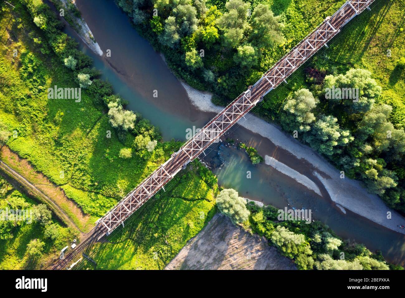 Steel railroad bridge above a river with blue water. Aerial drone view ...