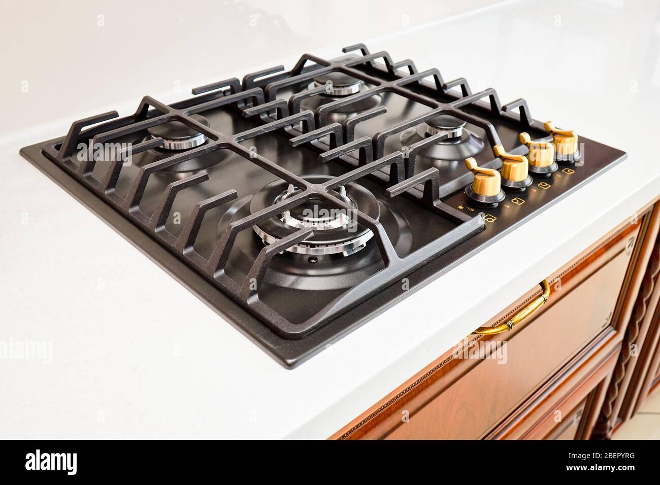 Modern hob gas stove made of steel and cast iron, with golden controls ...