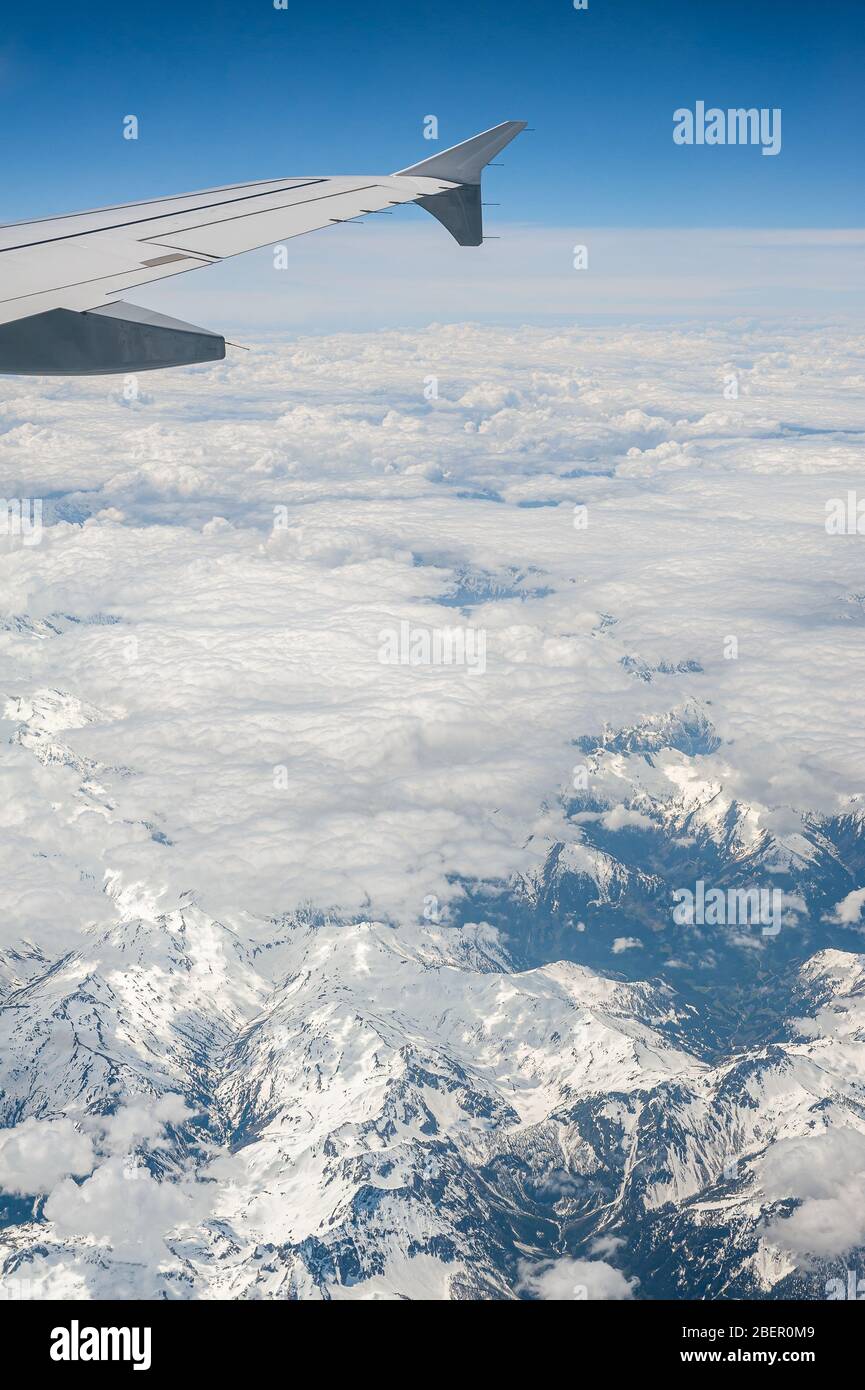 View from airborne airplane window at cloudy sky and Alps mountains ...