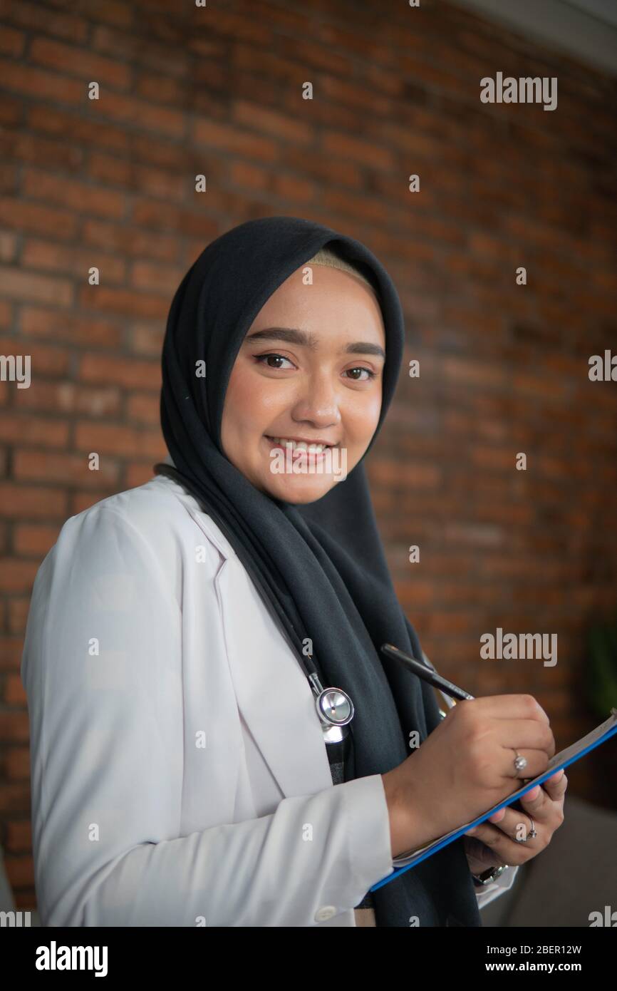 beautiful muslim doctor working at her clinic Stock Photo - Alamy