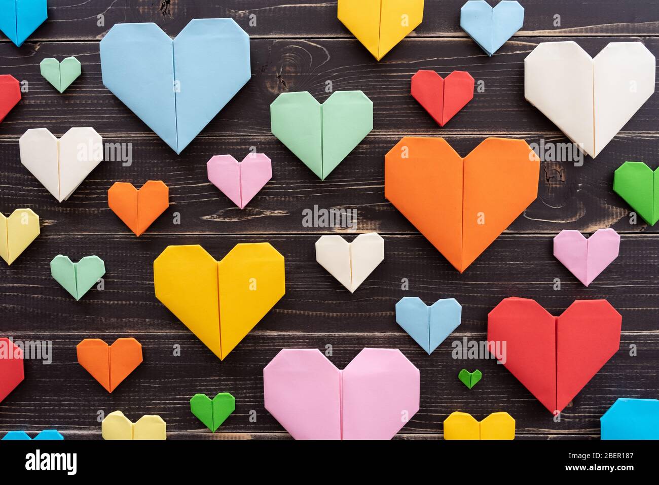 Origami hearts of different colors and sizes in composition on ...