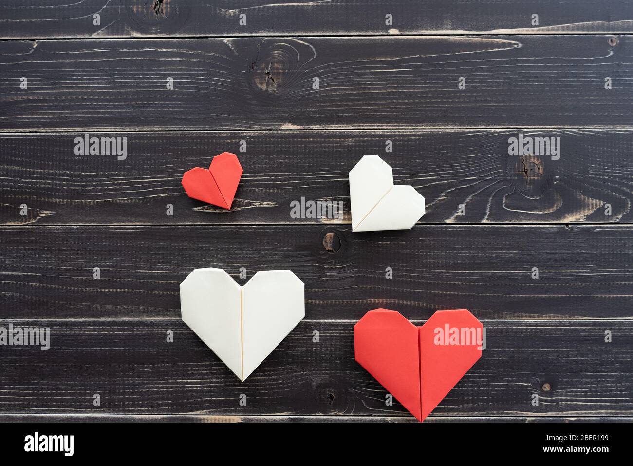 Origami hearts of different colors and sizes in composition on ...