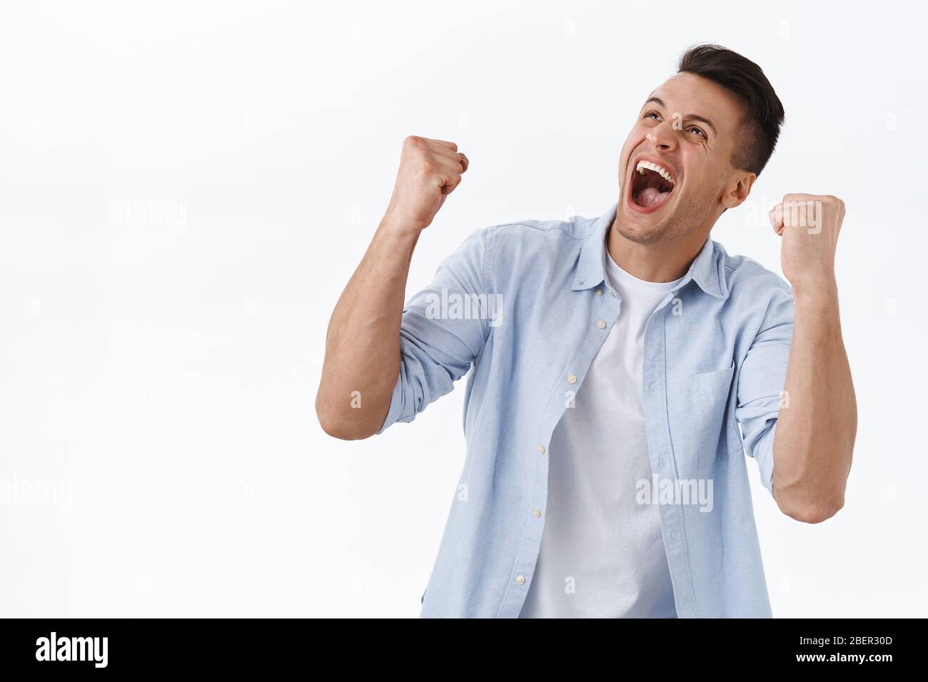 Portrait of excited handsome man looking up at tv screen in sport pub ...