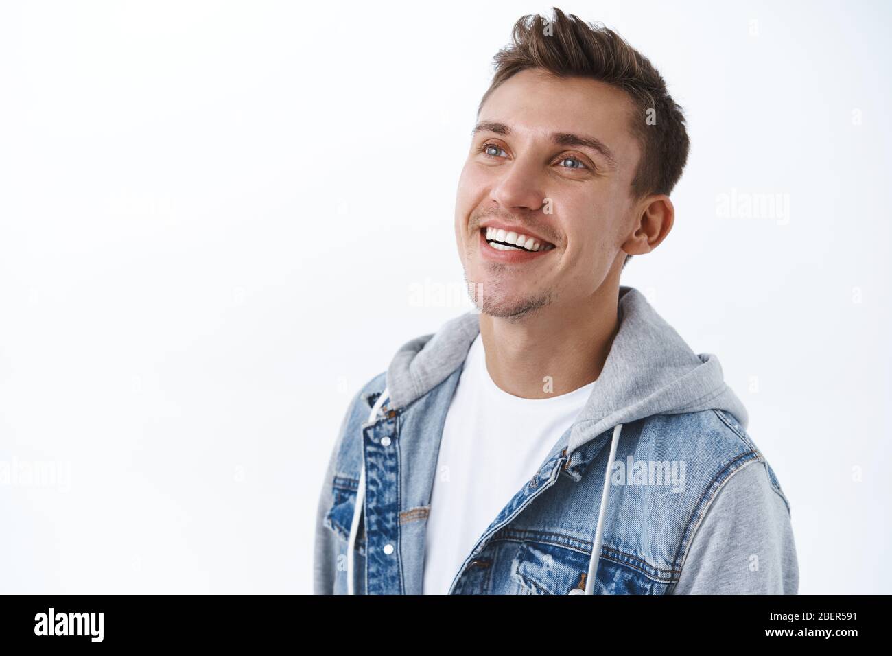Close-up portrait of dreamy, happy smiling blond man looking upper left ...
