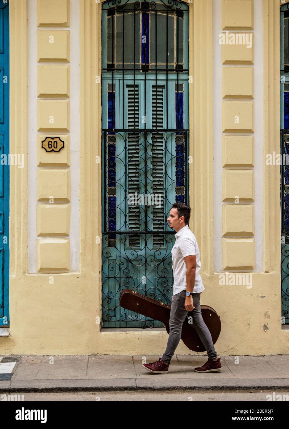 Cuban Musician walking with a guitar at La Habana Vieja, Havana, La ...