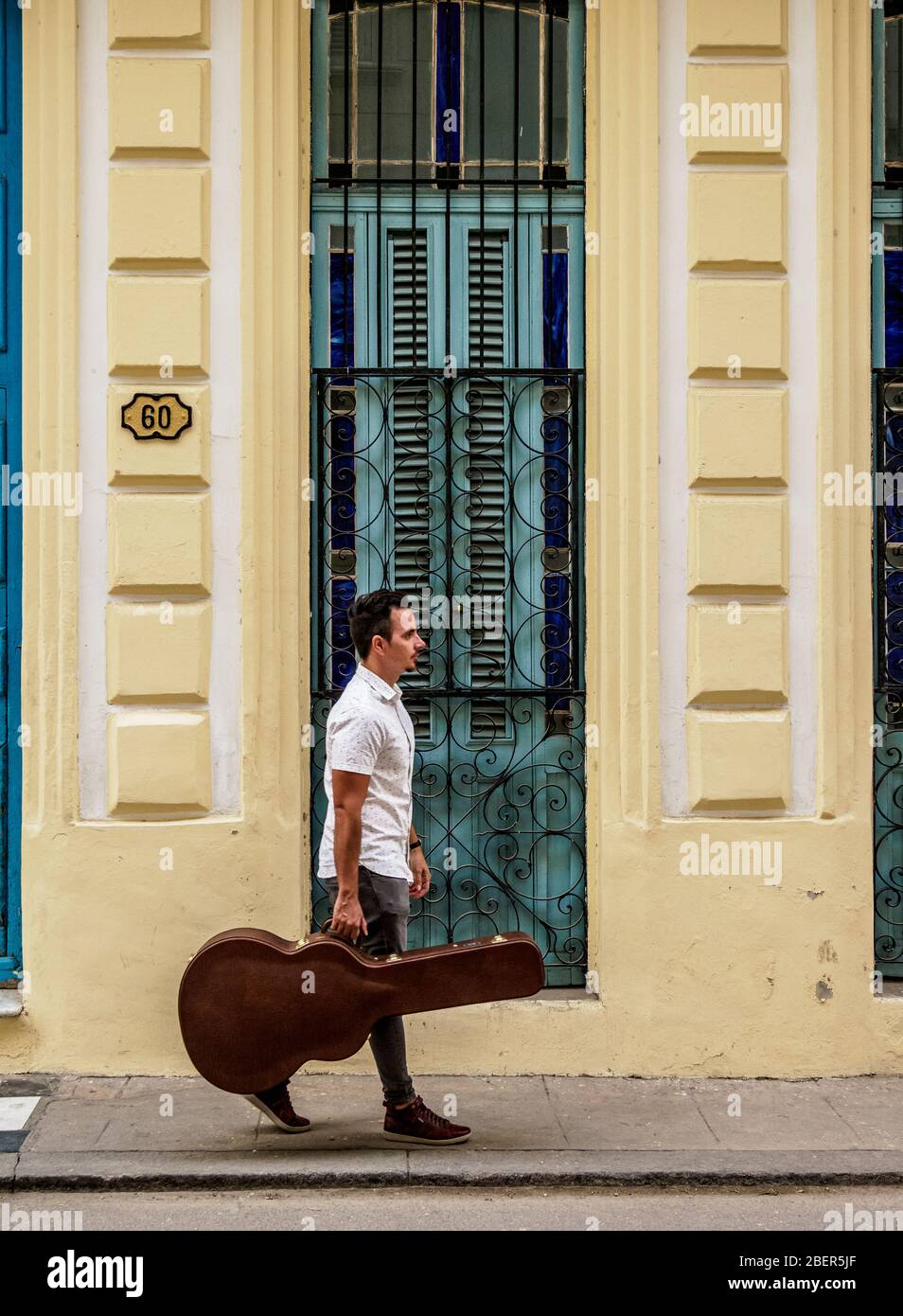Cuban Musician walking with a guitar at La Habana Vieja, Havana, La ...