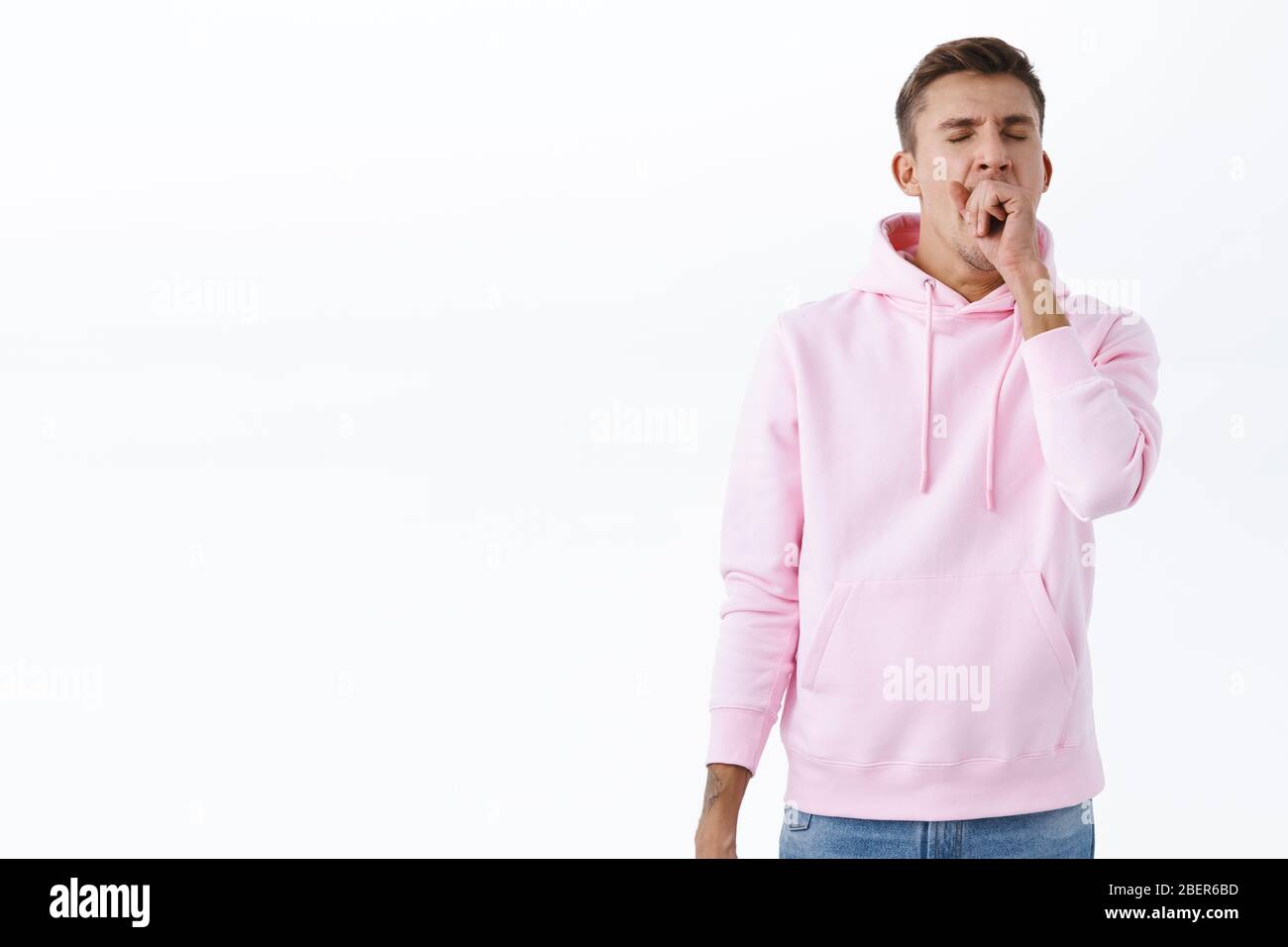 Portrait of sleepy handsome blond man in pink hoodie, close eyes and ...