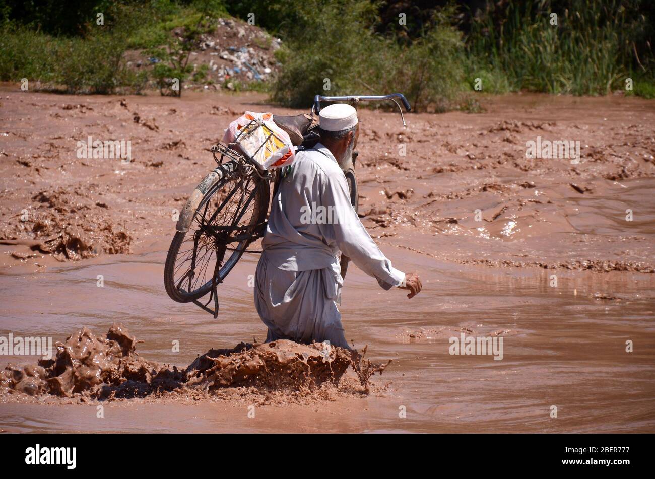 Peshawar, Pakistan. 15th Apr, 2020. Pakistanis walk in flood water ...