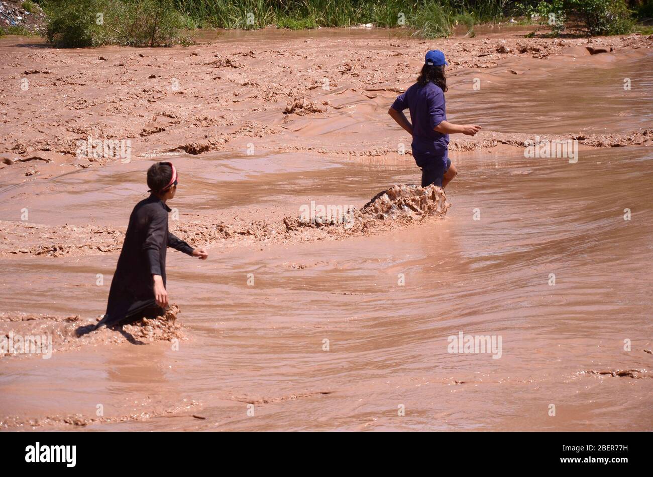Peshawar, Pakistan. 15th Apr, 2020. Pakistanis walk in flood water ...