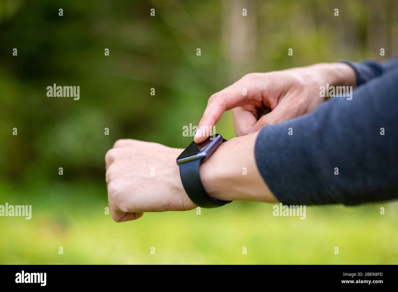 Man in nature using smartwatch app. Close-up hands Stock Photo - Alamy