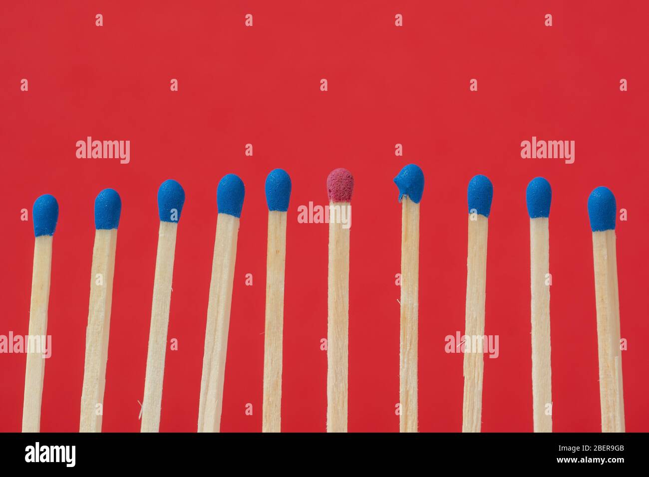 One red match stick standing out from the crowd of blue matches ...