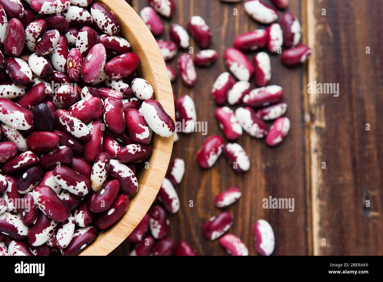 Violet with dots beans in wooden plate. Swallow beans. Vegetables for ...