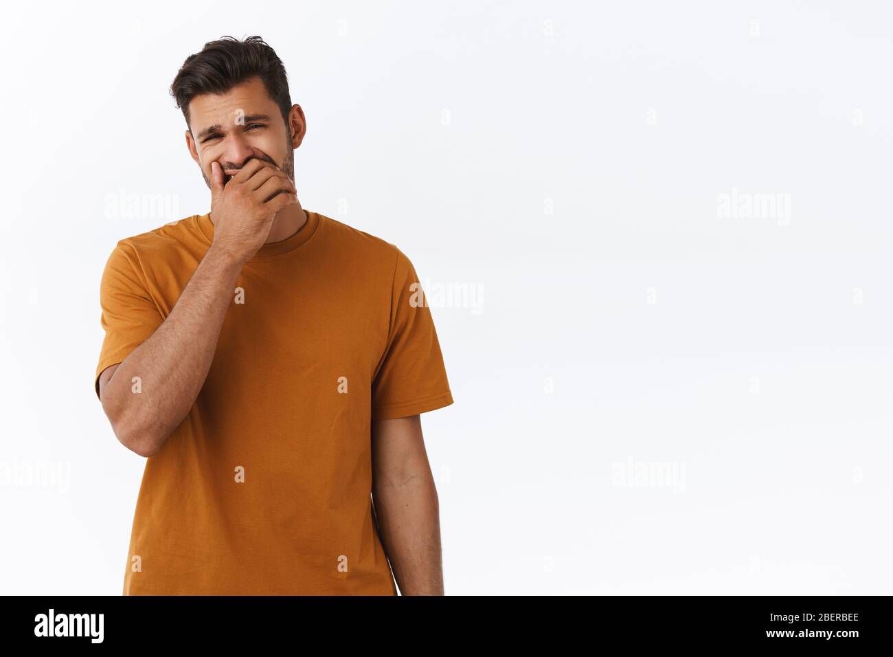 Bored, indifferent handsome bearded guy with stylish hipster haircut ...