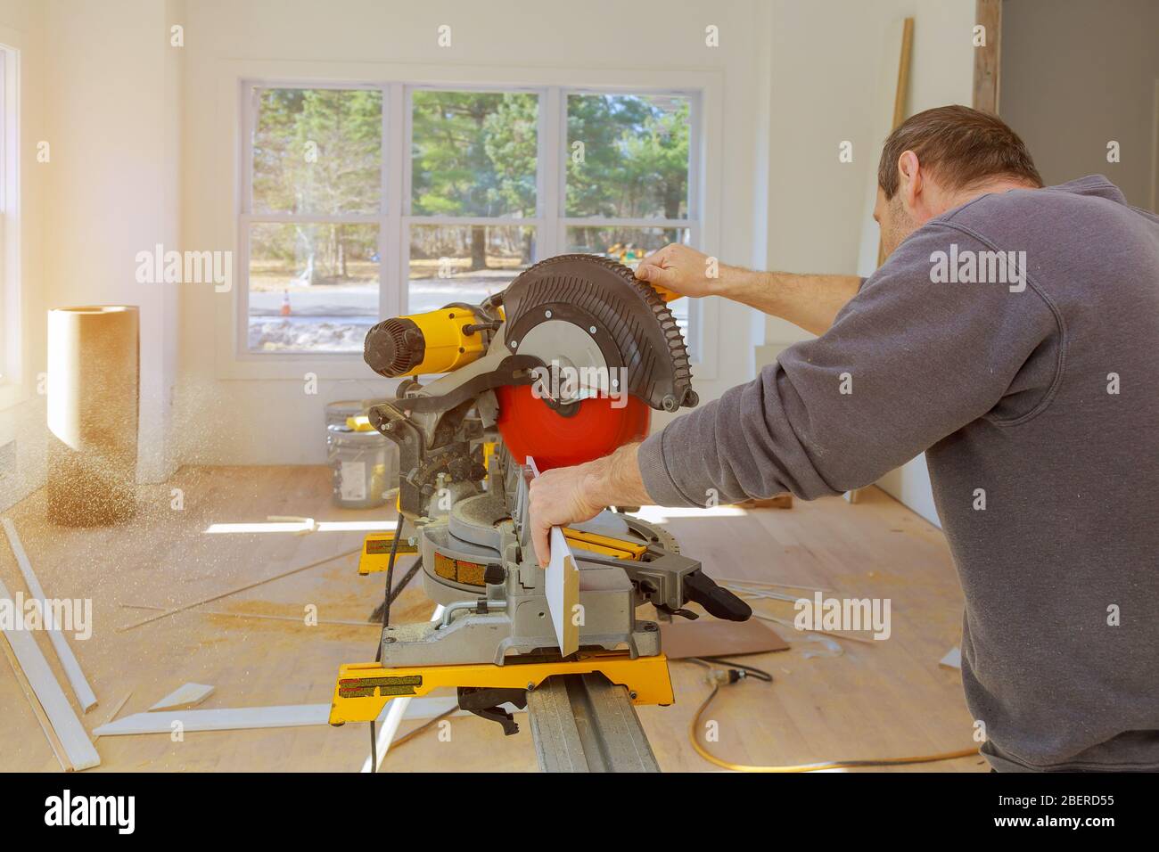 Working carpenter using circular saw rotating saw cutting wood ...