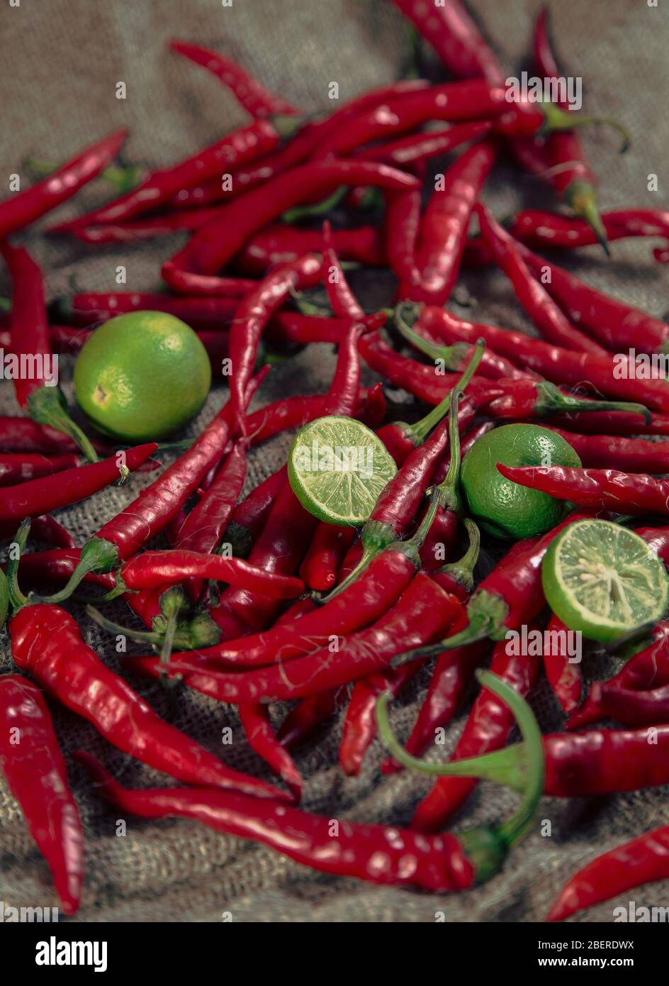 Red hot chilli peppers with lime on burlap sack. Close-up view of cut ...