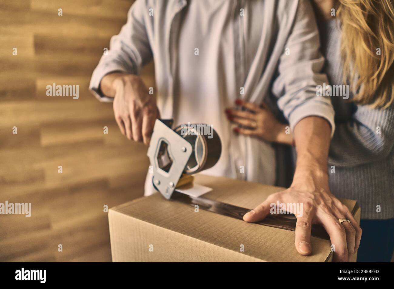 Attractive stylish man packing box to move into new house close-up ...