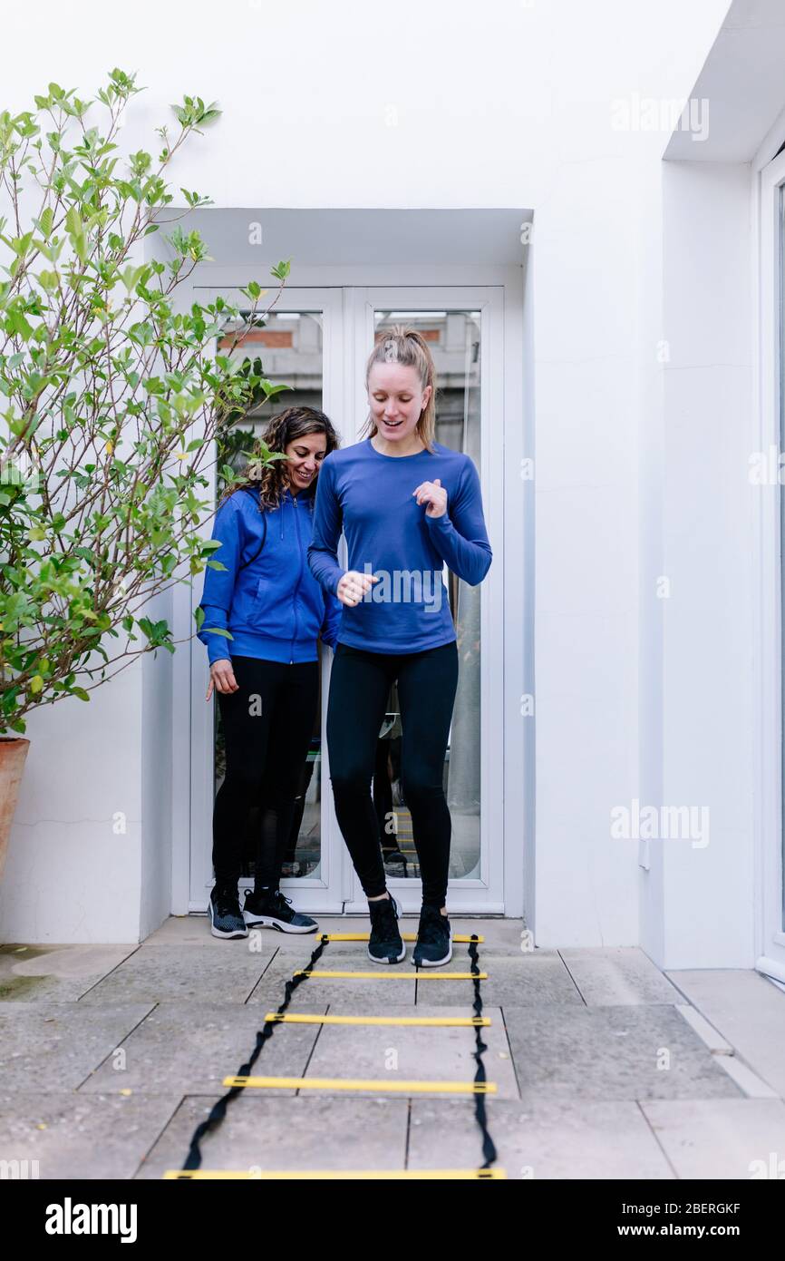 Two young women doing agility ladder exercise on a terrace Stock Photo ...