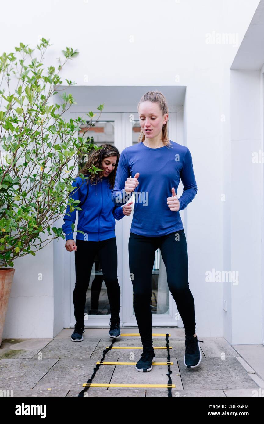Two young women doing agility ladder exercise on a terrace Stock Photo ...