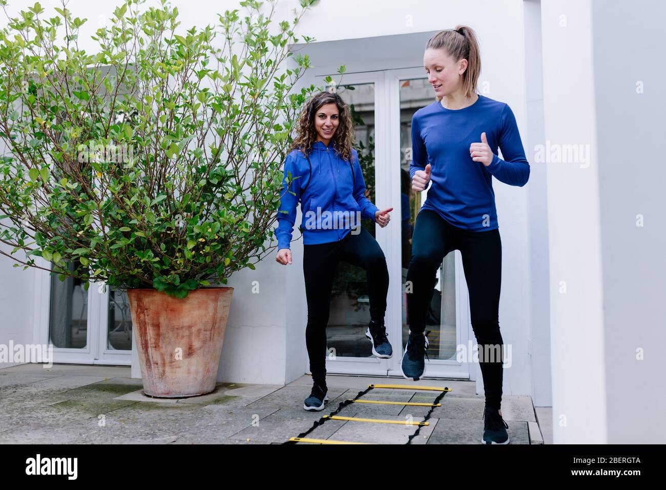 Two young women doing agility ladder exercise on a terrace Stock Photo ...