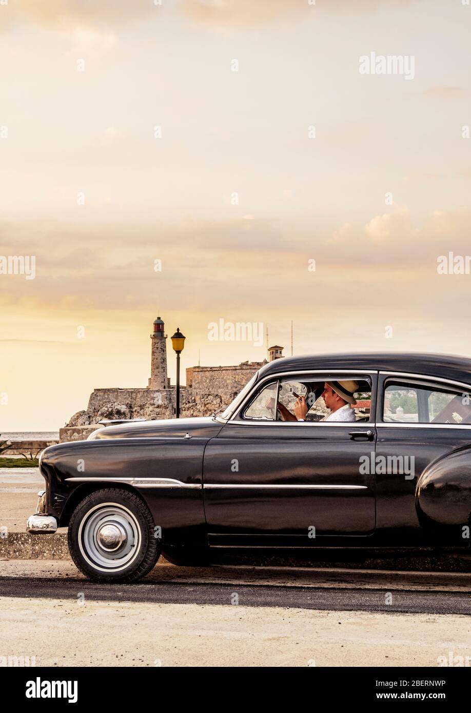 Cuban model smoking cigar in his Vintage Chevrolet Car at El Malecon ...