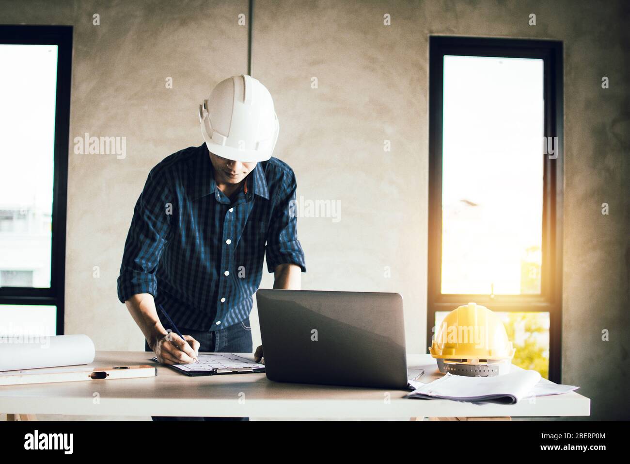 engineer working on blue print and search on laptop in construction ...