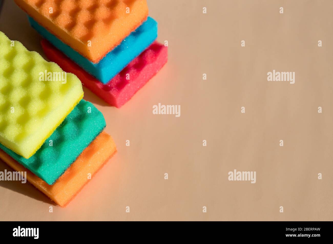 Brightly colored sponges on beige background with copy space.Bright ...
