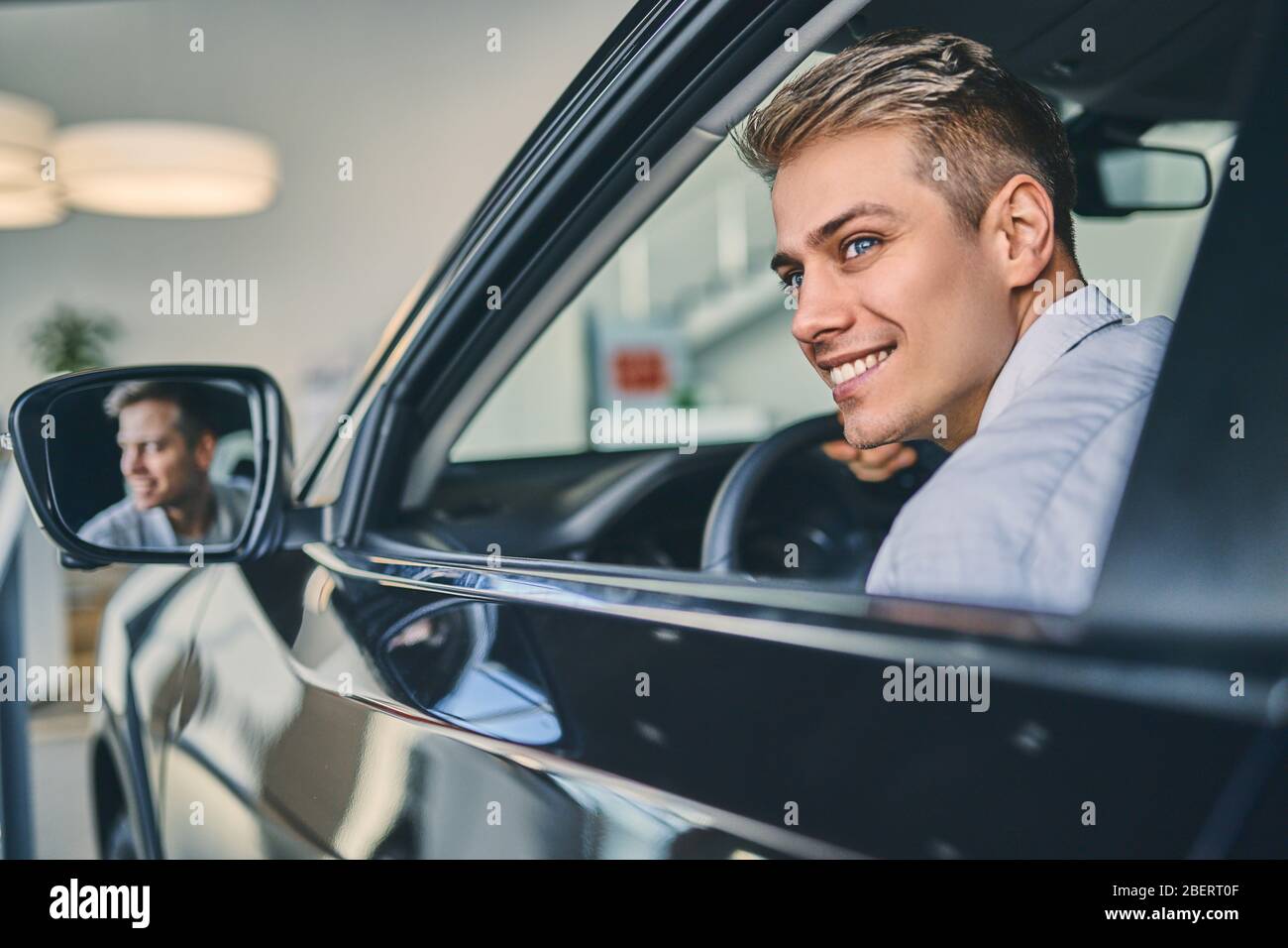 Stylish man sitting a new car and getting ready to drive Stock Photo ...