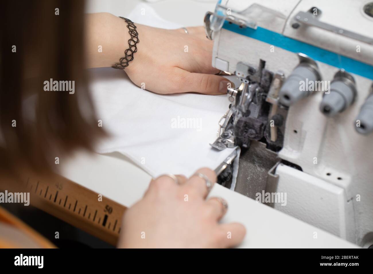 A young girl learns to sew on a specialized sewing machine Stock Photo ...