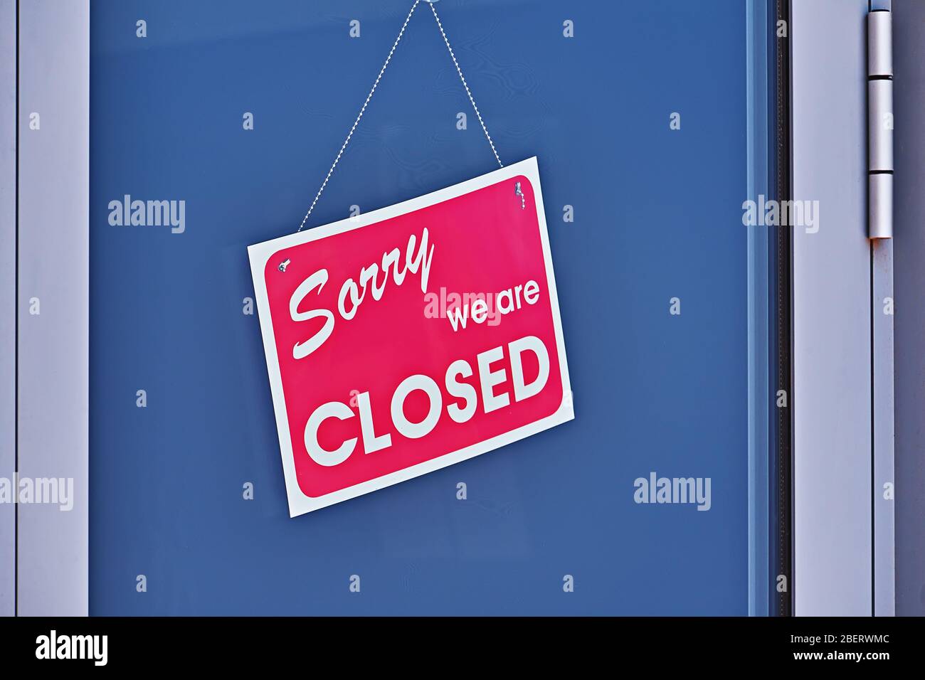 Signboard with inscription SORRY WE ARE CLOSED on glass closed-door ...