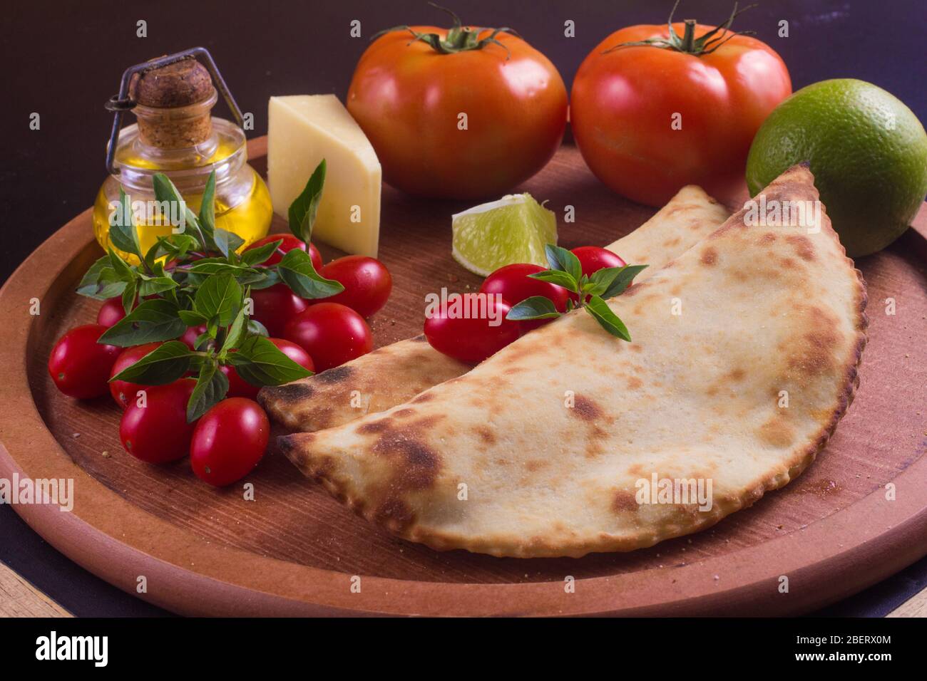 Traditional Italian meet Calzone with tomatoes and lemon Stock Photo ...