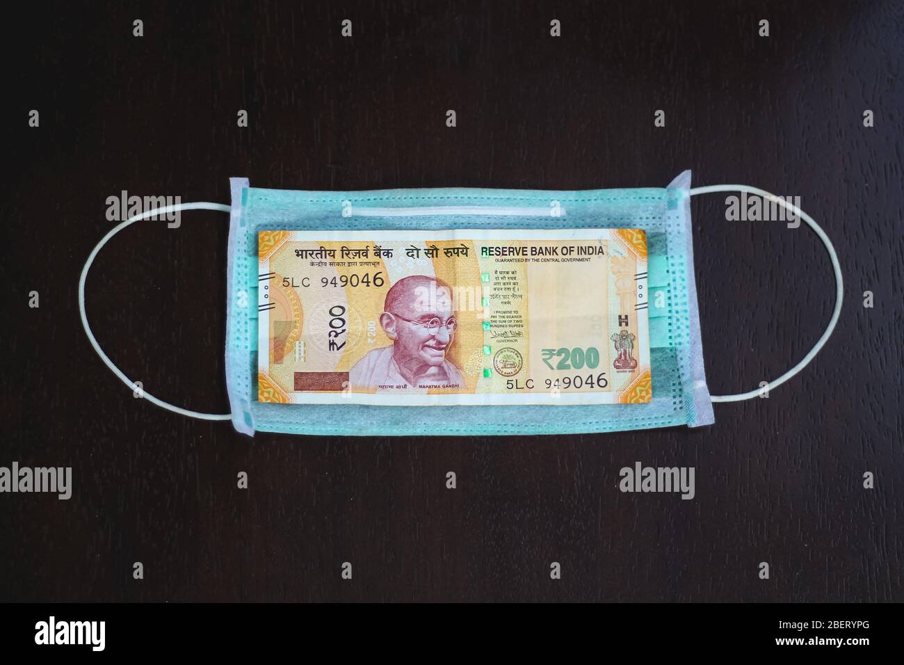 Protective face mask and Rupees isolated on a dark background from Top ...