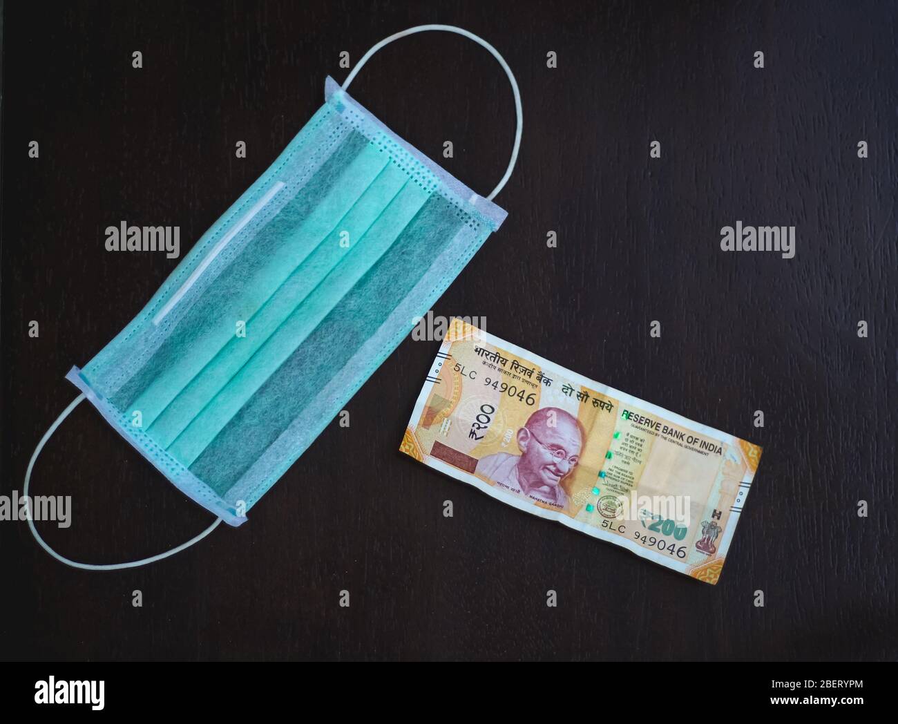 Protective face mask and Rupees isolated on a dark background from Top ...