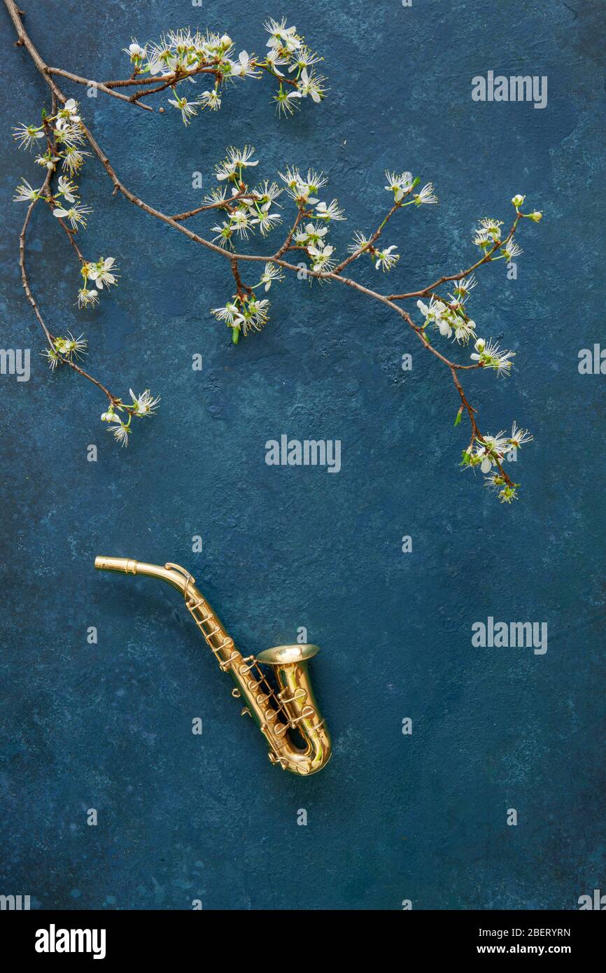 Little Golden saxophone and blossoming cherry tree branches. Top view ...