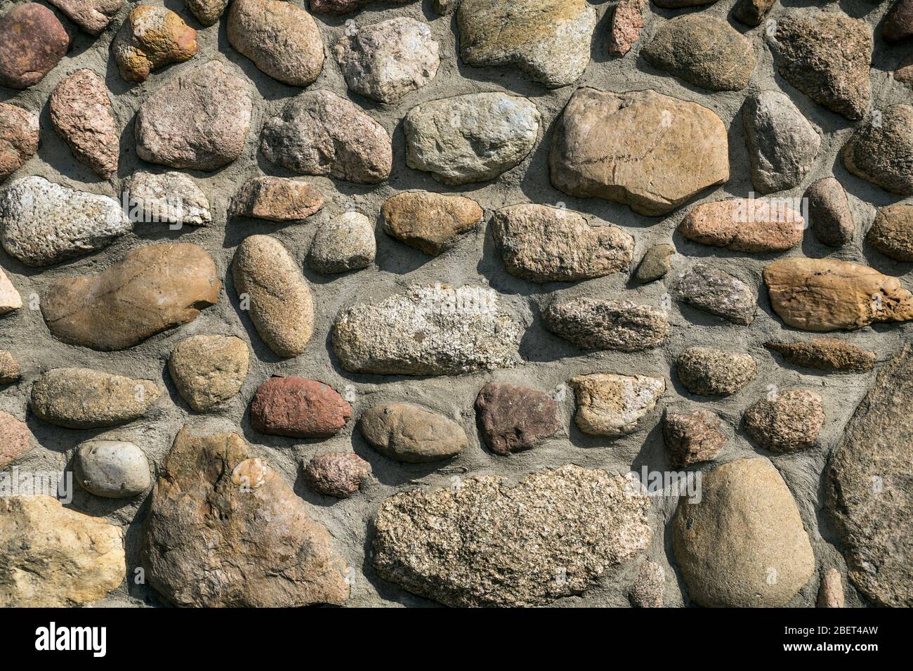 Stones fixed with cement mortar. A wall of pebble stones Stock Photo ...