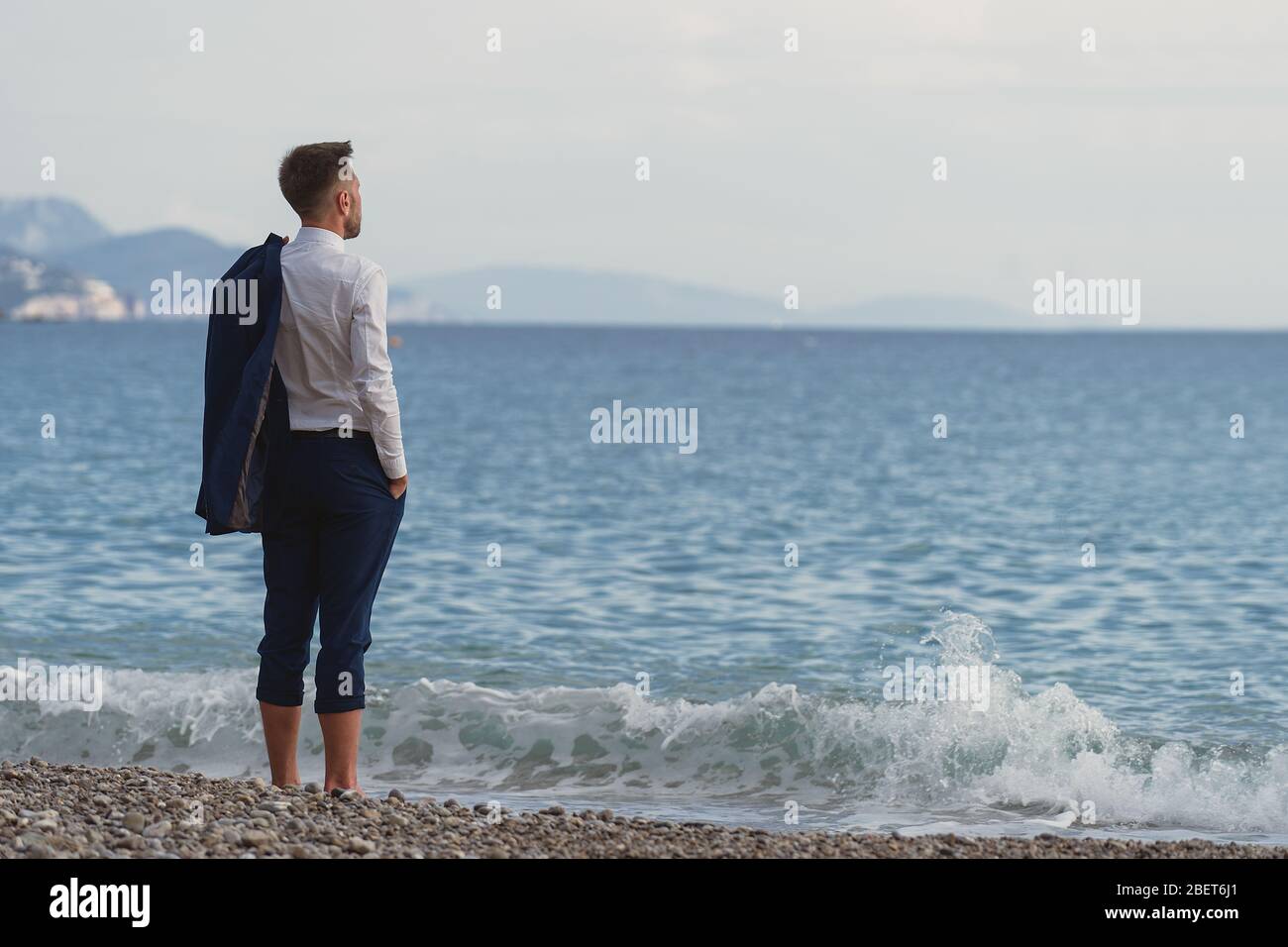 Businessman standing barefoot on the beach Stock Photo - Alamy