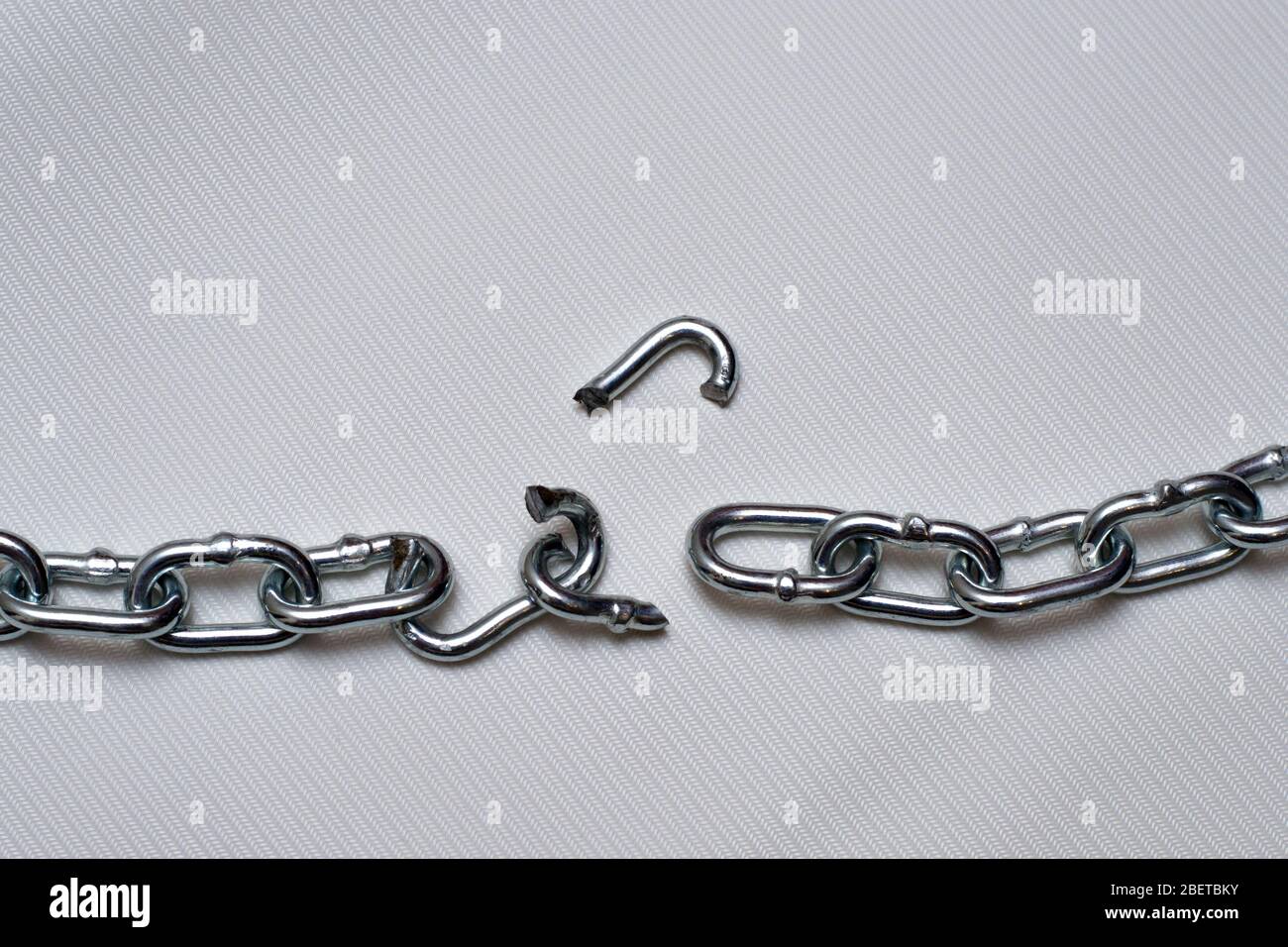Photo of broken metallic chain on white background Stock Photo - Alamy